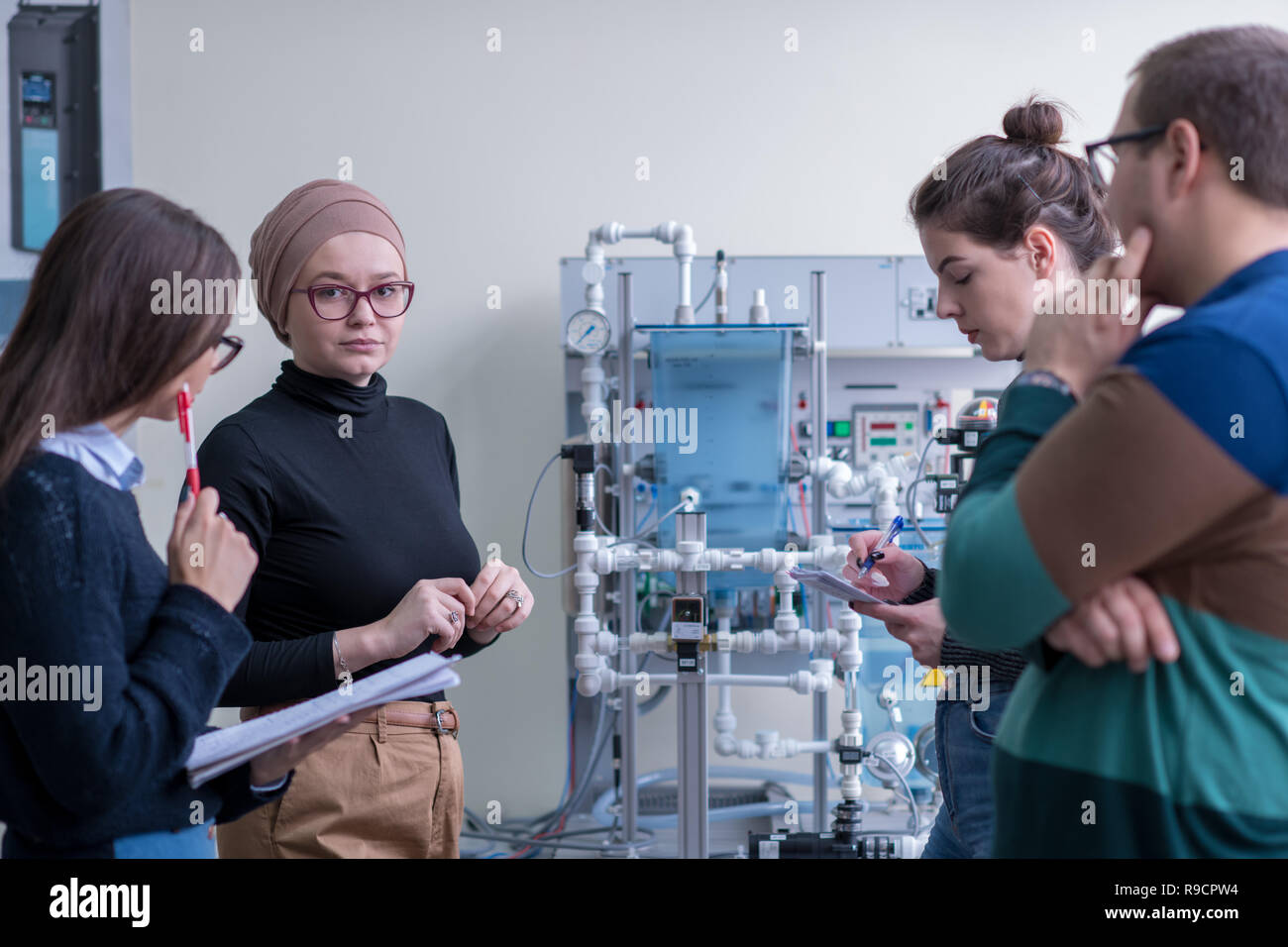 Group of students doing technical vocational practice with young female ...
