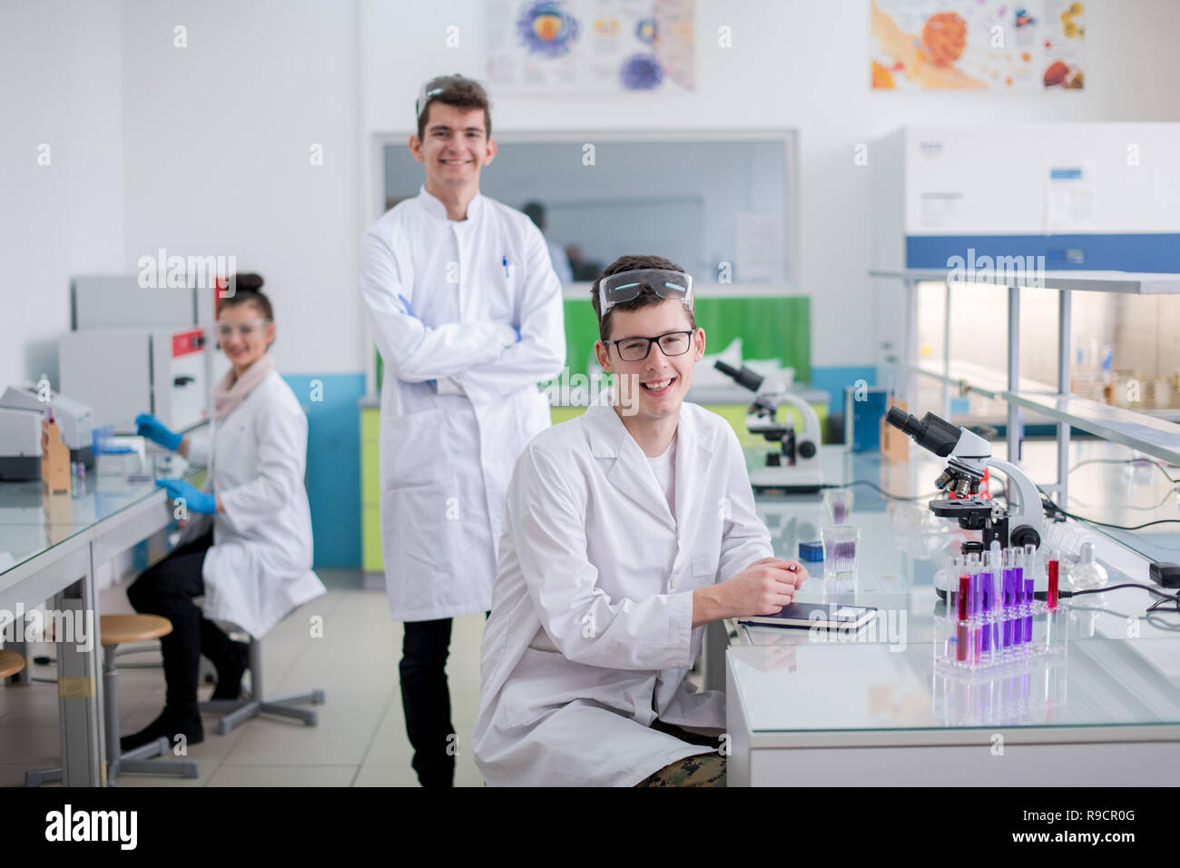 Group of young medical students doing research together in chemistry ...