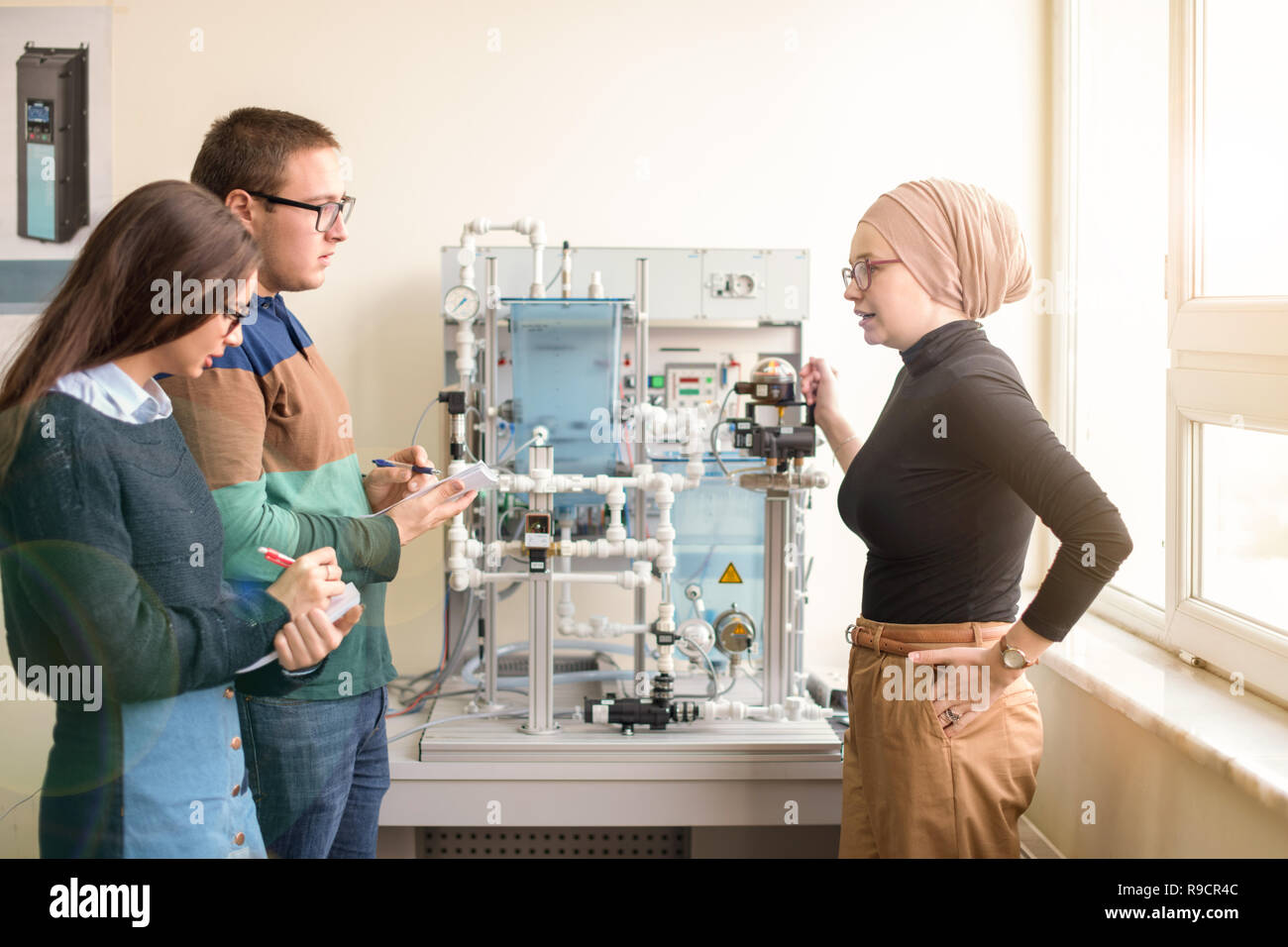 Group of students doing technical vocational practice with young female ...