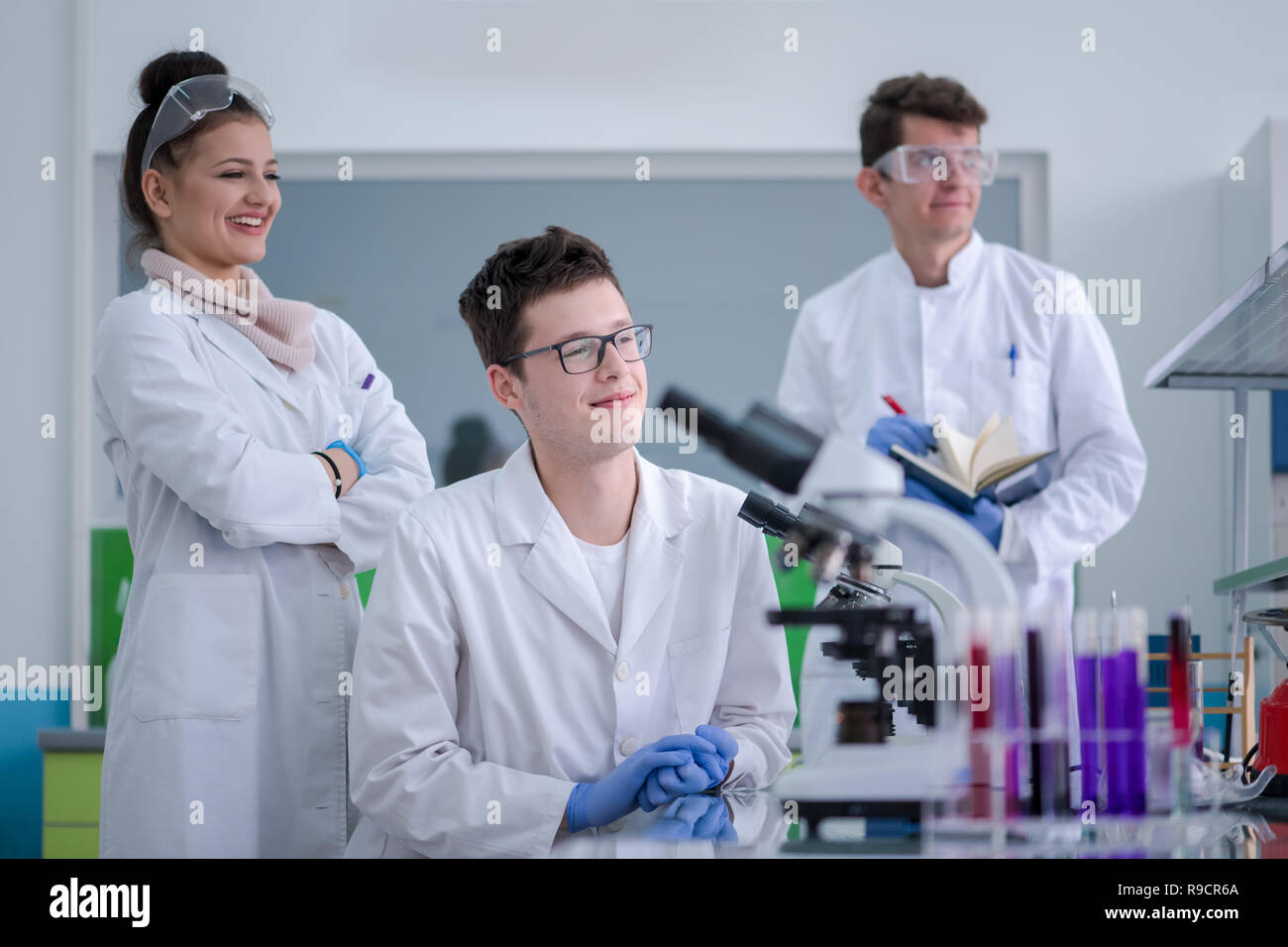 Group of young medical students doing research together in chemistry ...