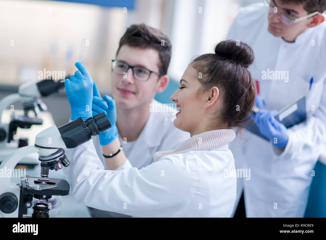 Group of young medical students doing research together in chemistry ...