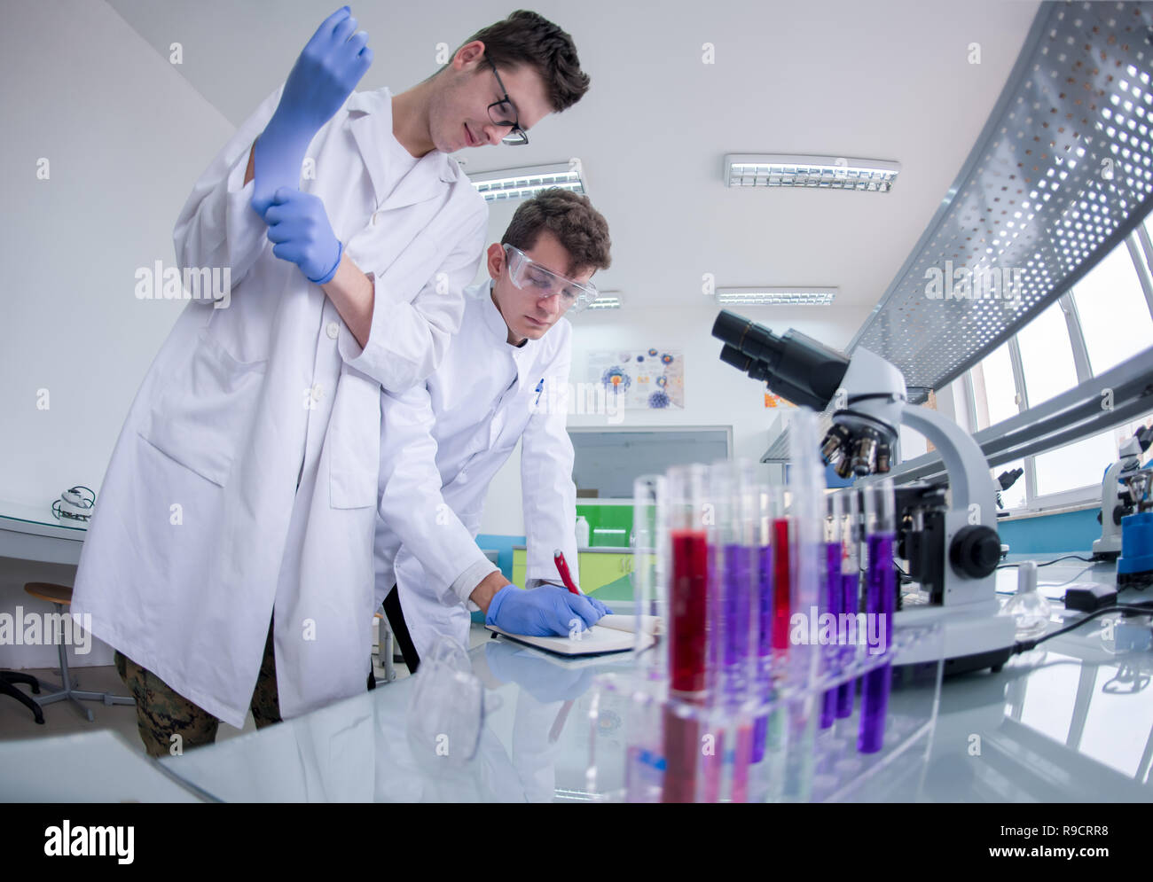 Group of young medical students doing research together in chemistry ...