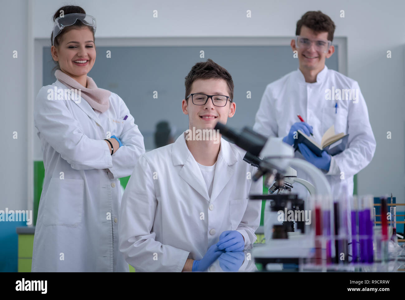 Group of young medical students doing research together in chemistry ...