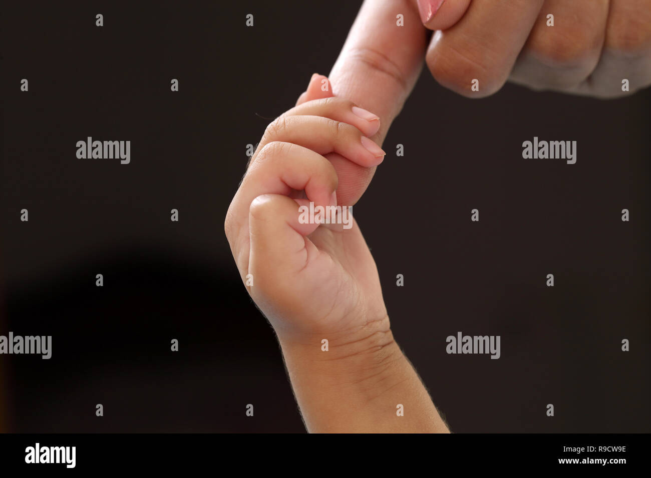 Newborn baby gripping mothers finger Stock Photo - Alamy