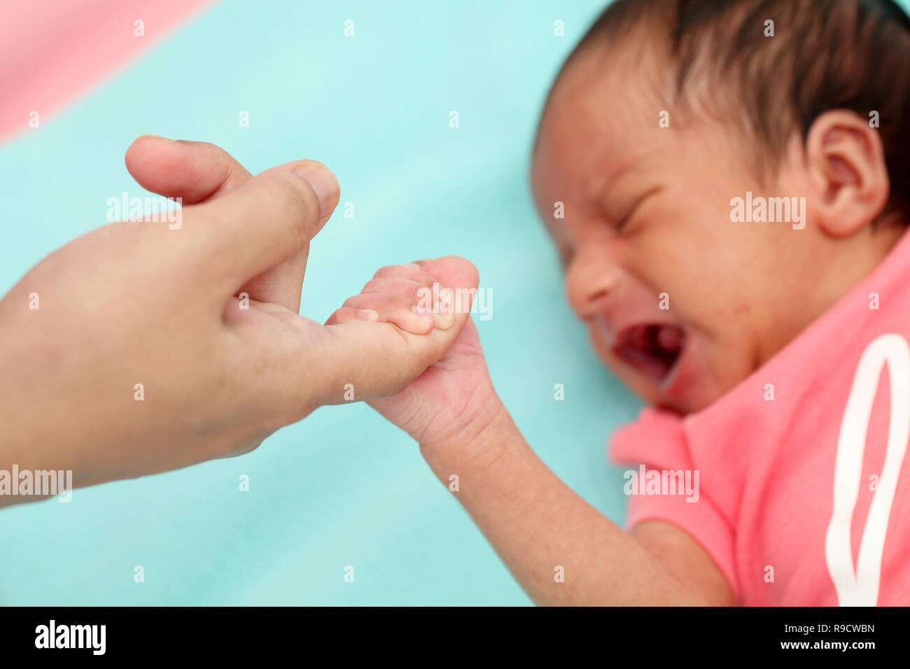 Newborn baby gripping mothers finger Stock Photo - Alamy