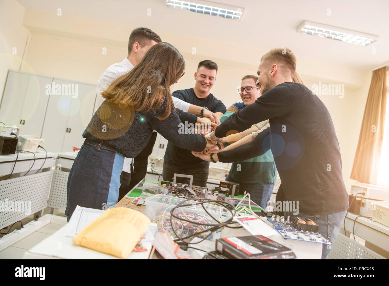 Group of young students in electronics classroom celebrating ...