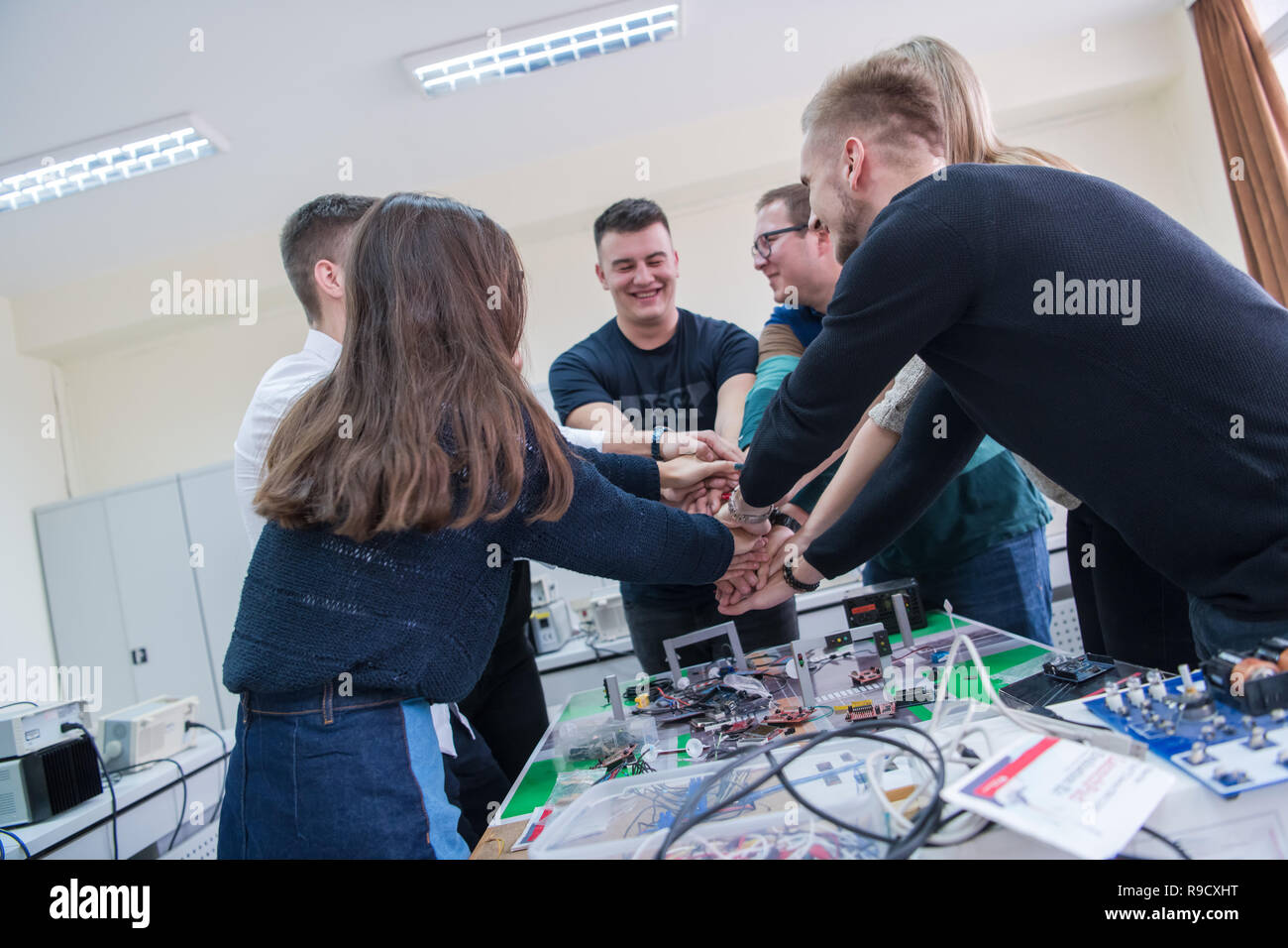 Group of young students in electronics classroom celebrating ...