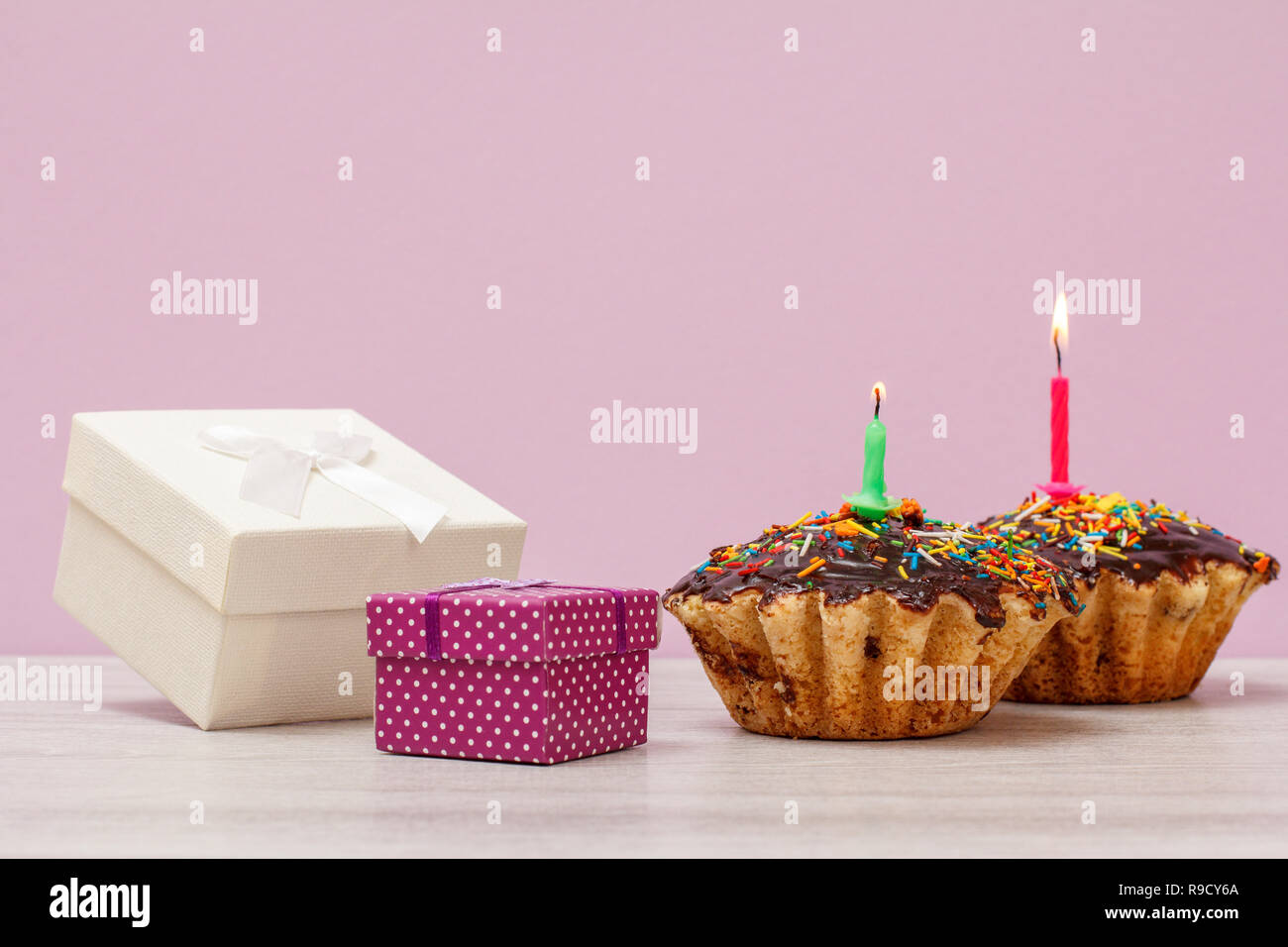 Gift boxes and two tasty birthday muffins with chocolate glaze and ...