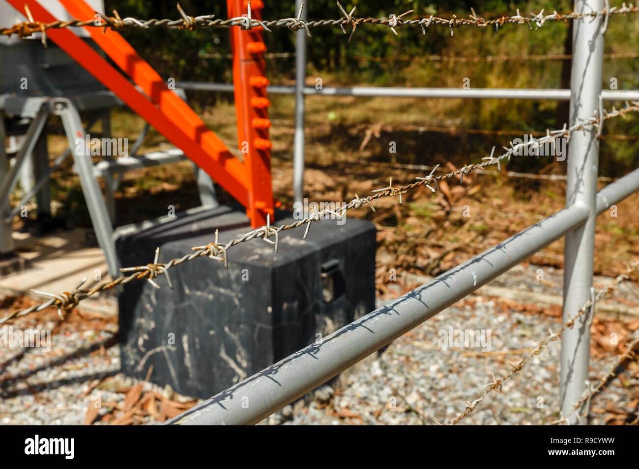barbed wire fence around cell tower Stock Photo - Alamy