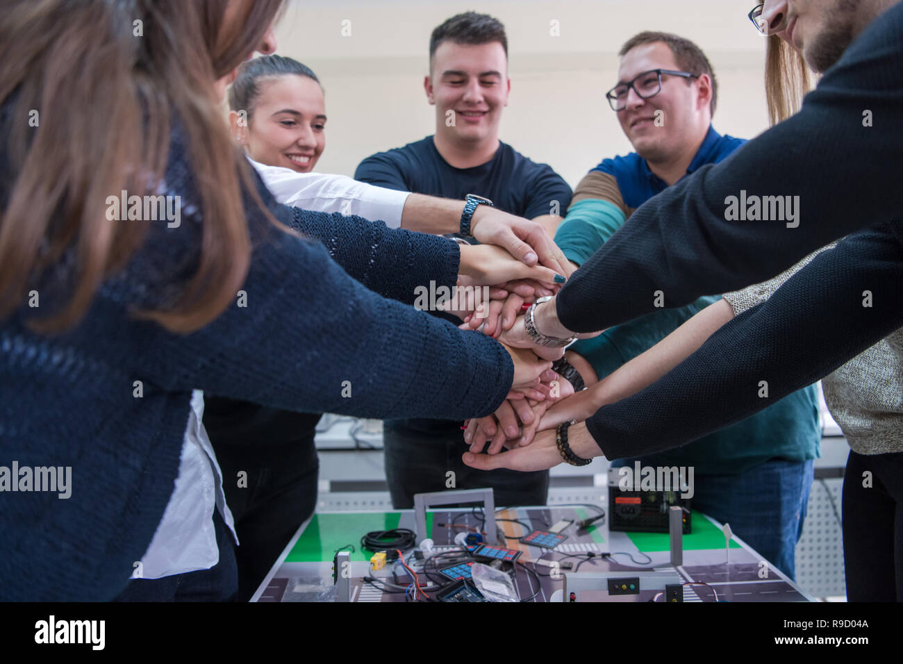 Group of young students in electronics classroom celebrating ...