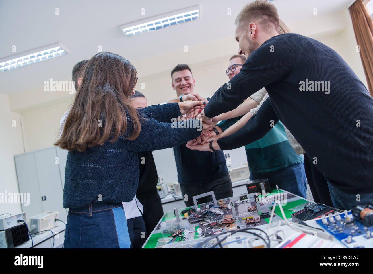 Group of young students in electronics classroom celebrating ...