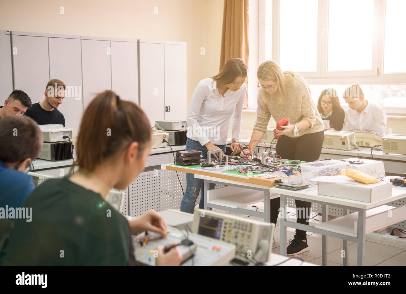 Group of young students doing technical vocational practice with ...