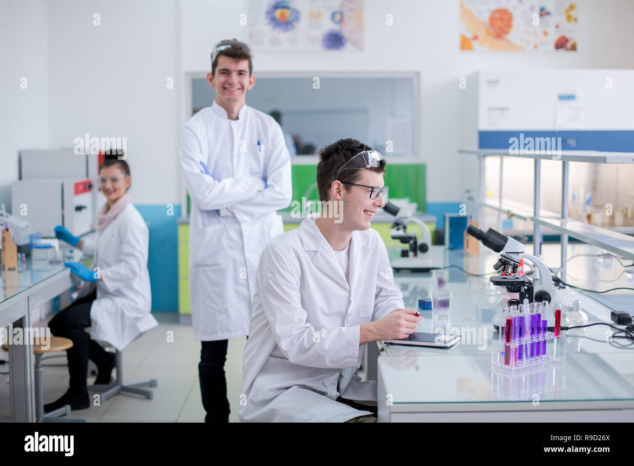 Group of young medical students doing research together in chemistry ...