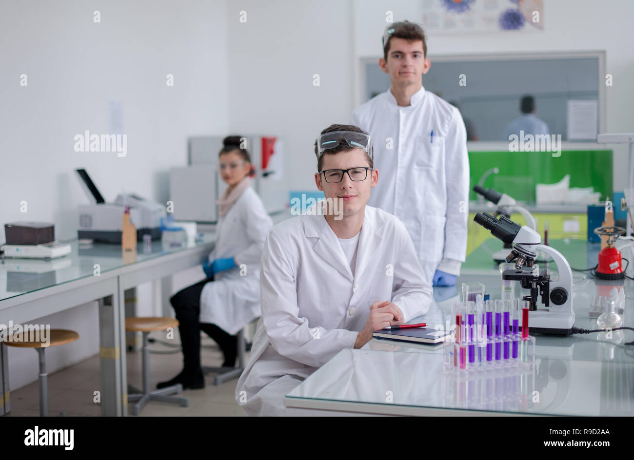 Group of young medical students doing research together in chemistry ...