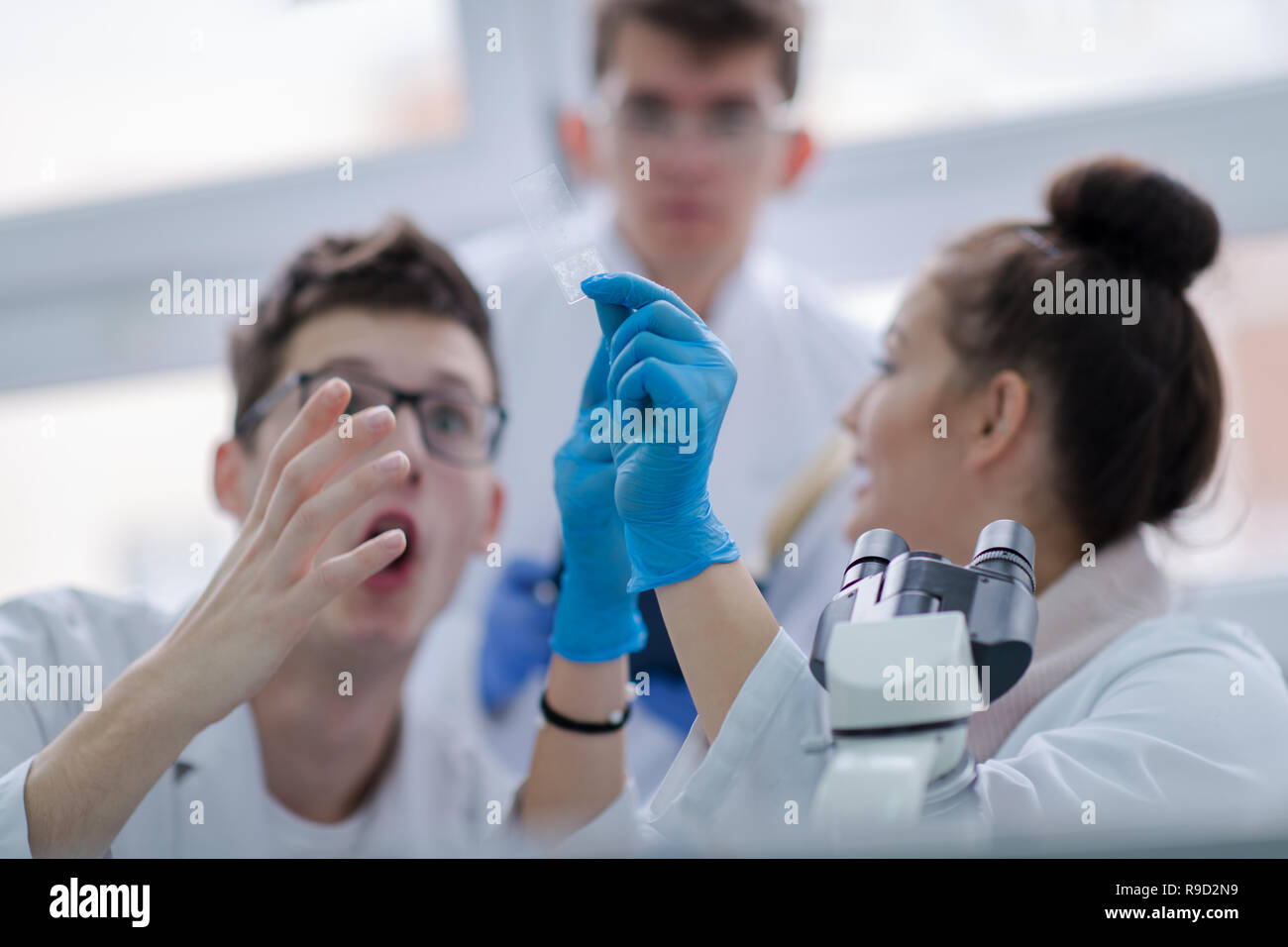 Group of young medical students doing research together in chemistry ...