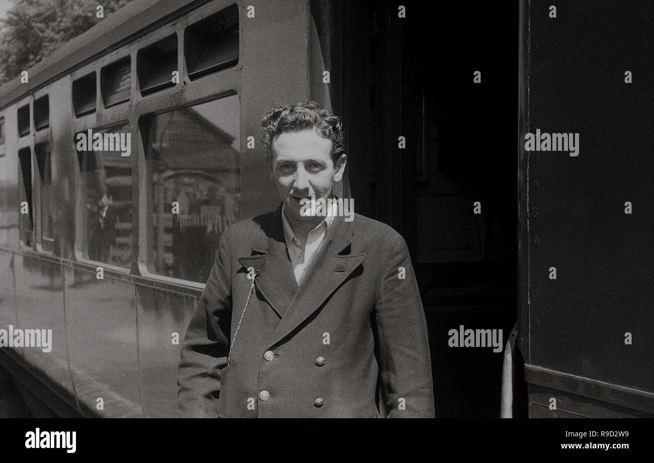 1950s, historical, a young male British Railways guard standing outside ...