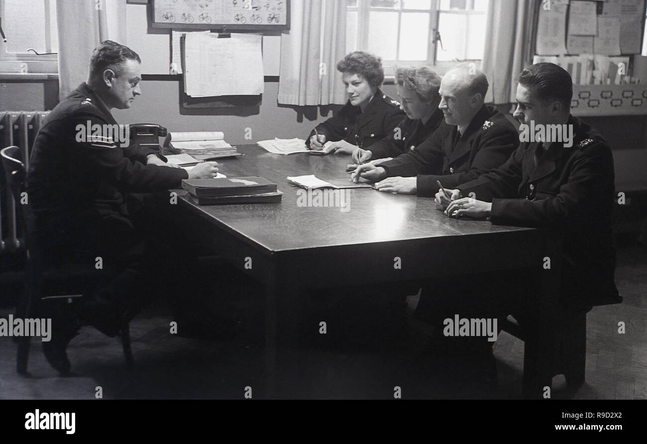 1950s, historical, a police sergeant having a meeting at a table with ...