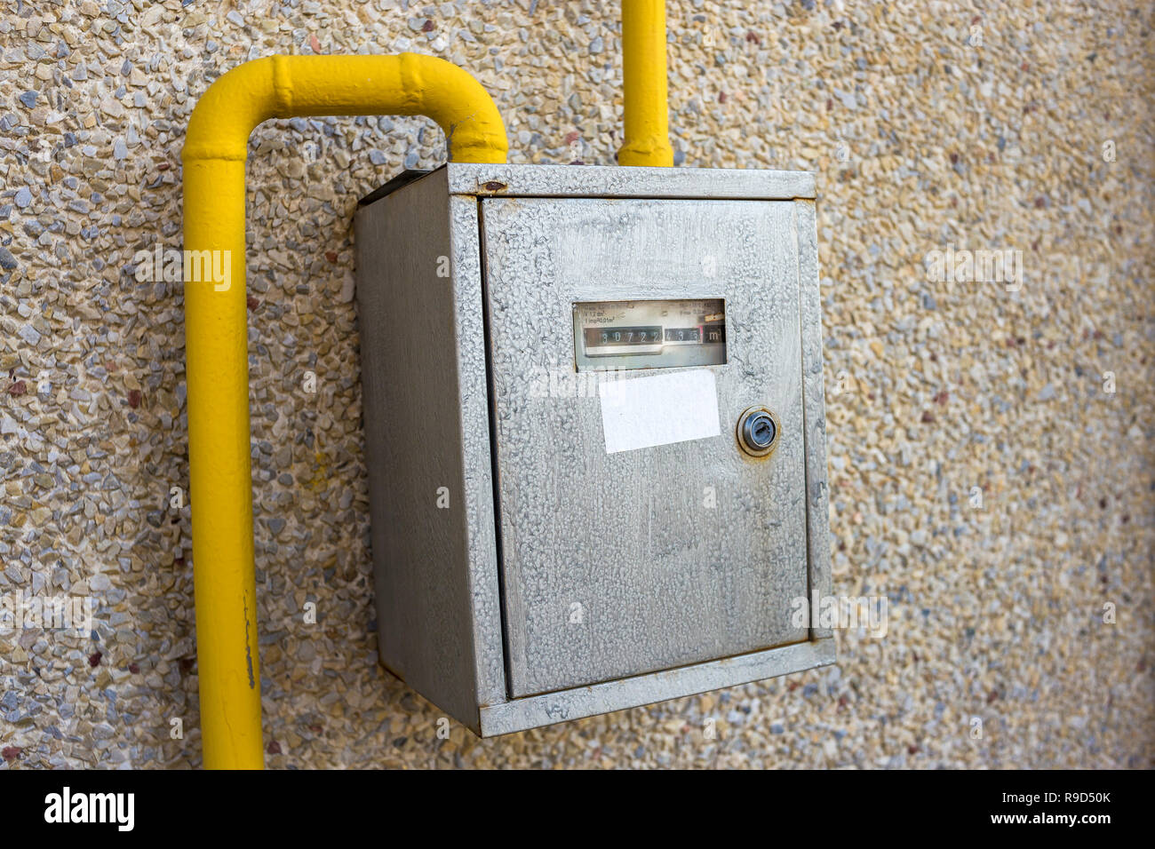 Close-up of metal steel gas meter box with connecting yellow pipes ...