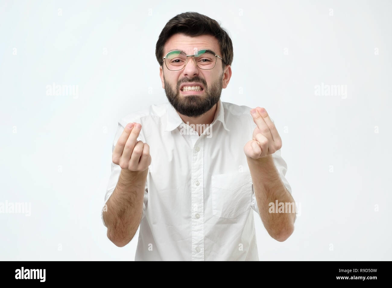 Furious man with grumpy grimace on his face,with mouth opened in shout ...