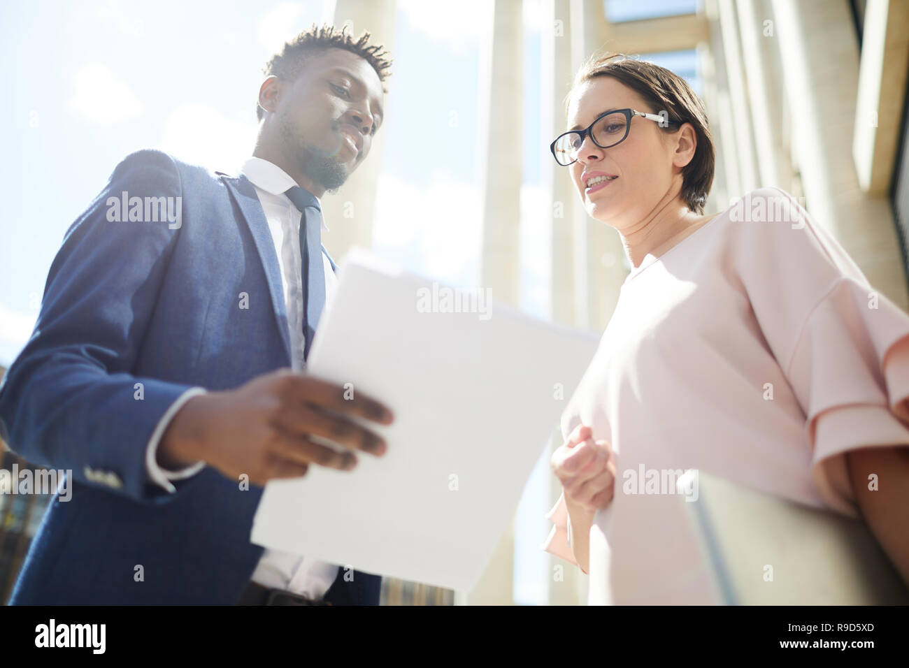 Business colleagues discussing papers Stock Photo - Alamy