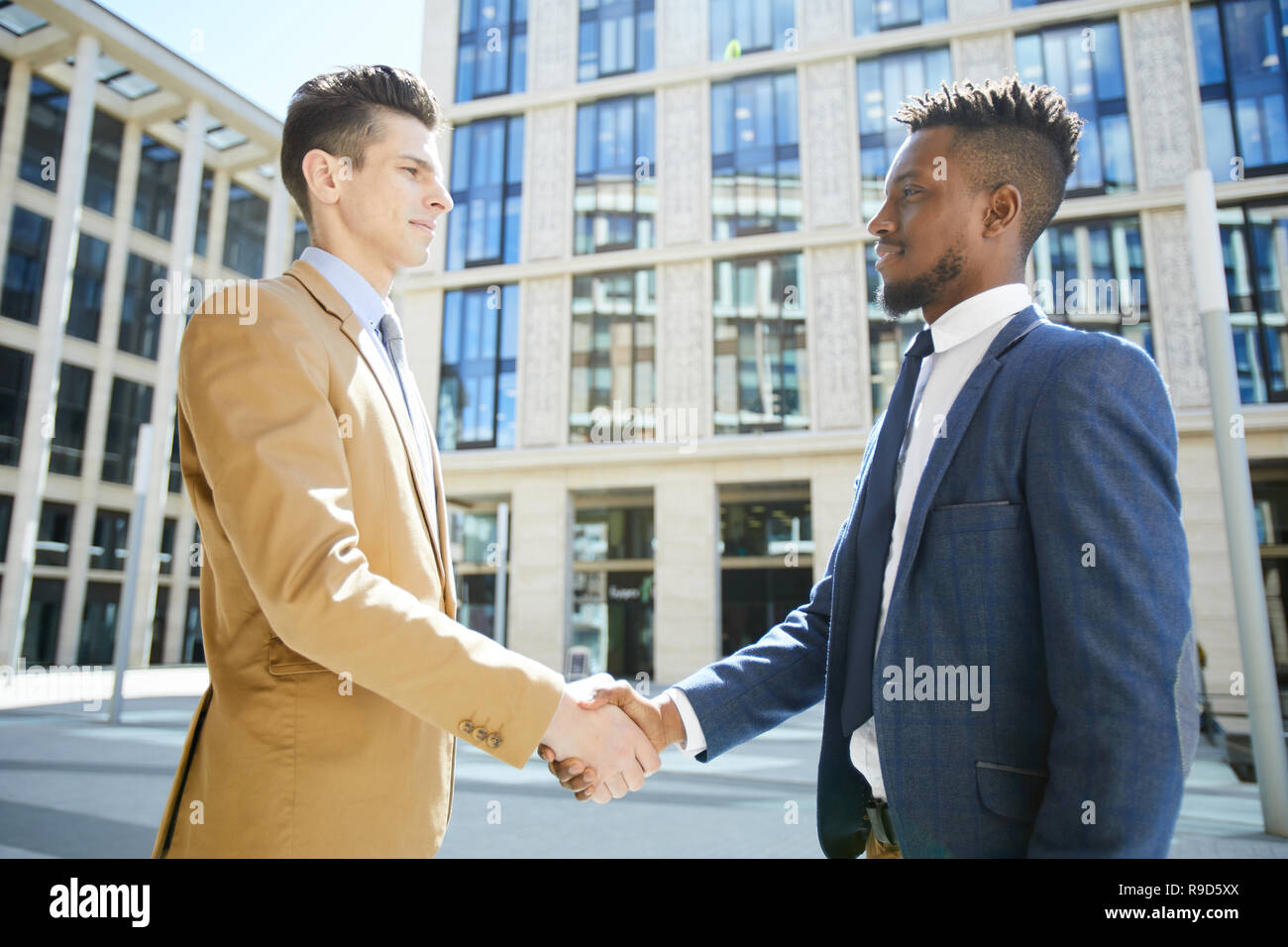 Business partners shaking hands in financial district Stock Photo - Alamy
