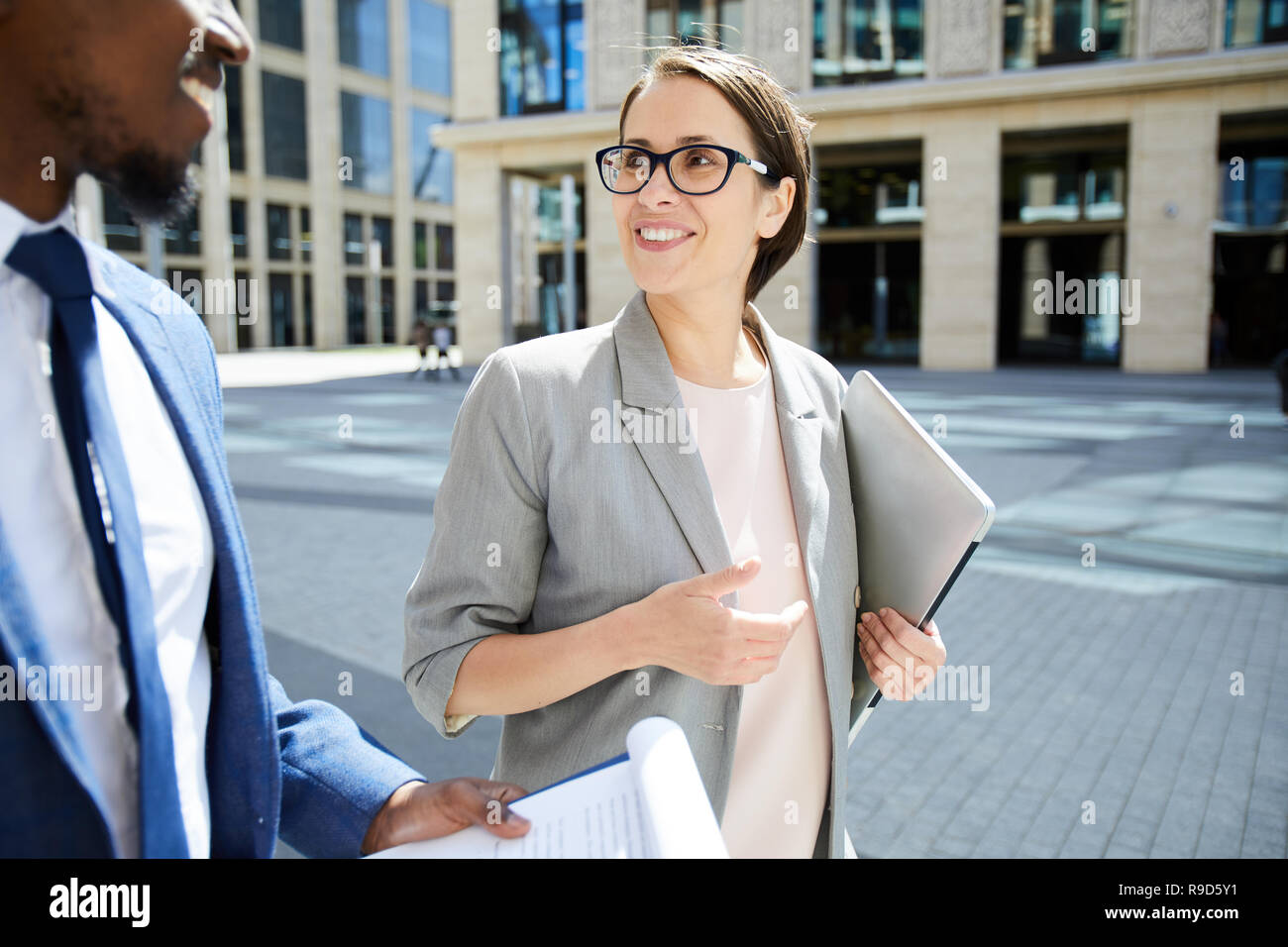 Positive colleagues communicating while commuting Stock Photo - Alamy