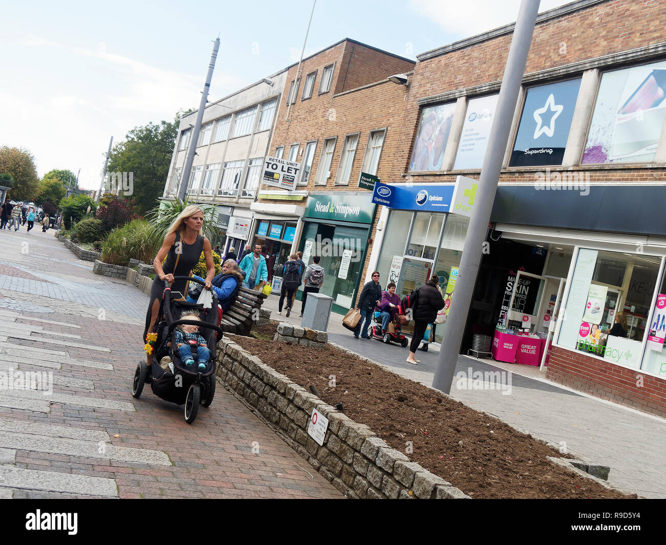 UK High street shoppers shopping and visitors browsing shop fronts ...