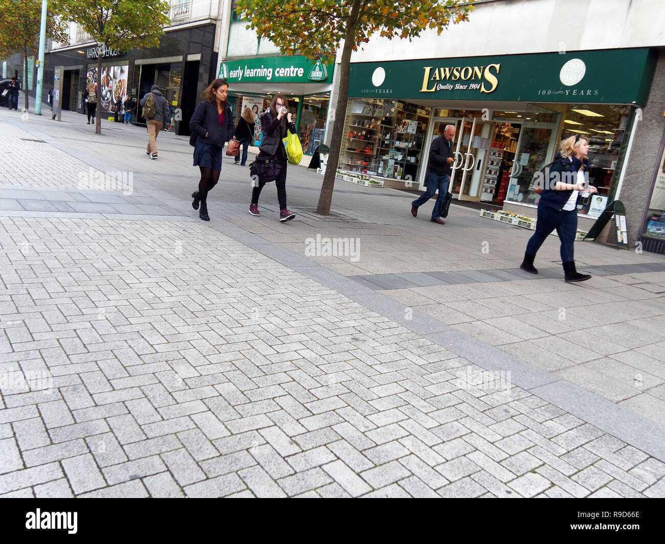 UK High street shoppers shopping and visitors browsing shop fronts ...