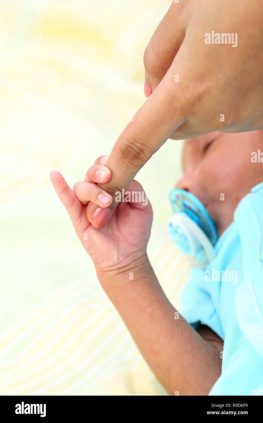 Newborn baby gripping mothers finger Stock Photo - Alamy