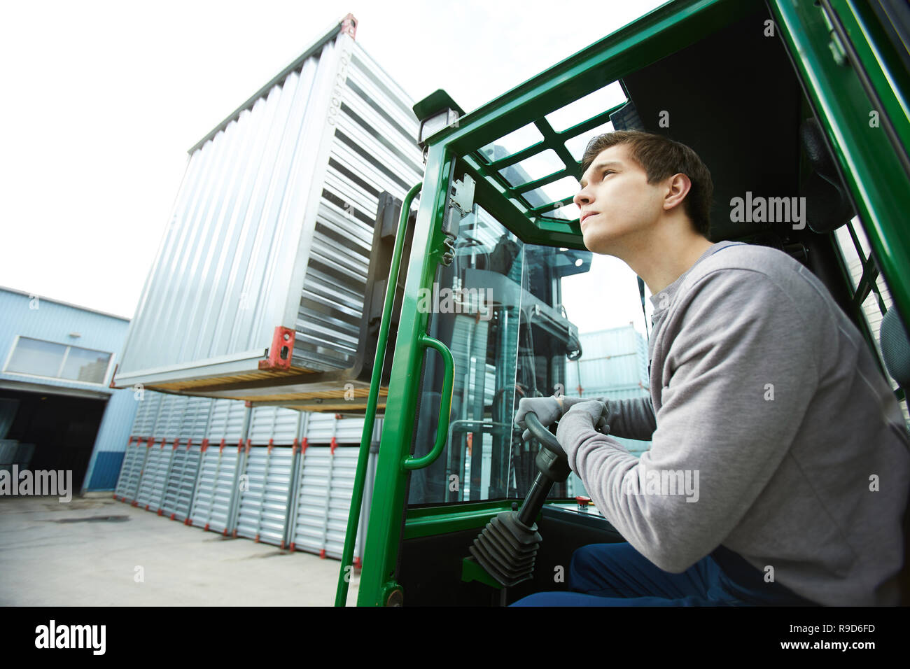 Serious man operating forklift Stock Photo - Alamy