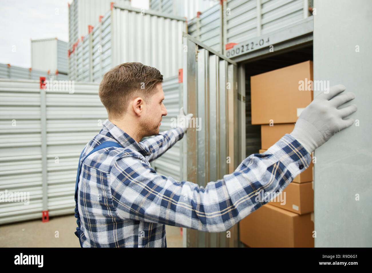 Worker opening cargo container Stock Photo - Alamy
