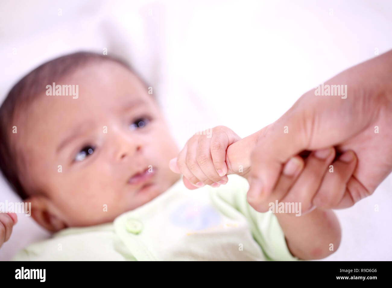 Newborn baby gripping mothers finger Stock Photo - Alamy