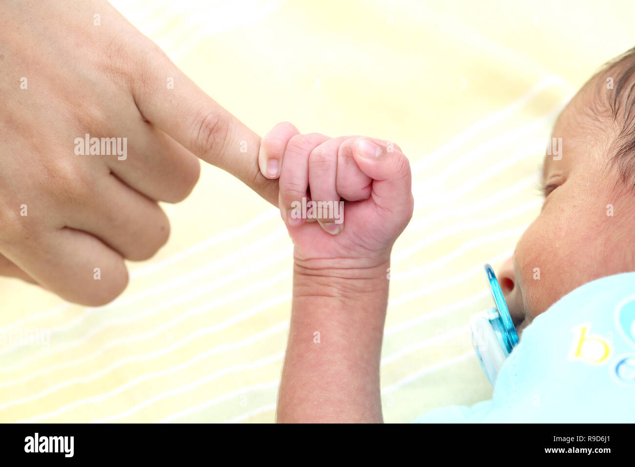 Newborn baby gripping mothers finger Stock Photo - Alamy