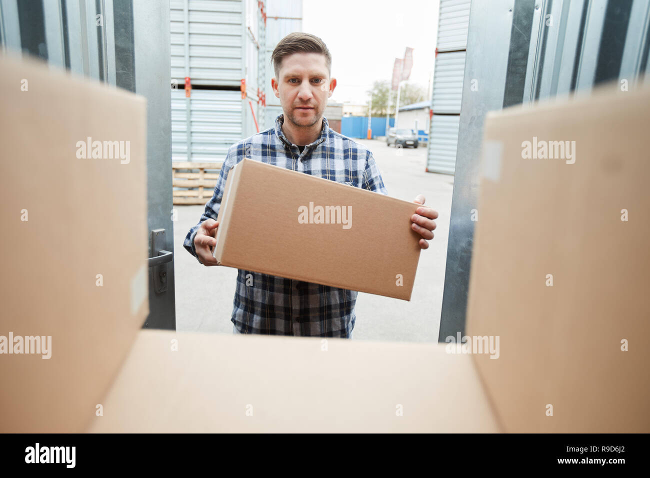 Man loading container with boxes Stock Photo - Alamy