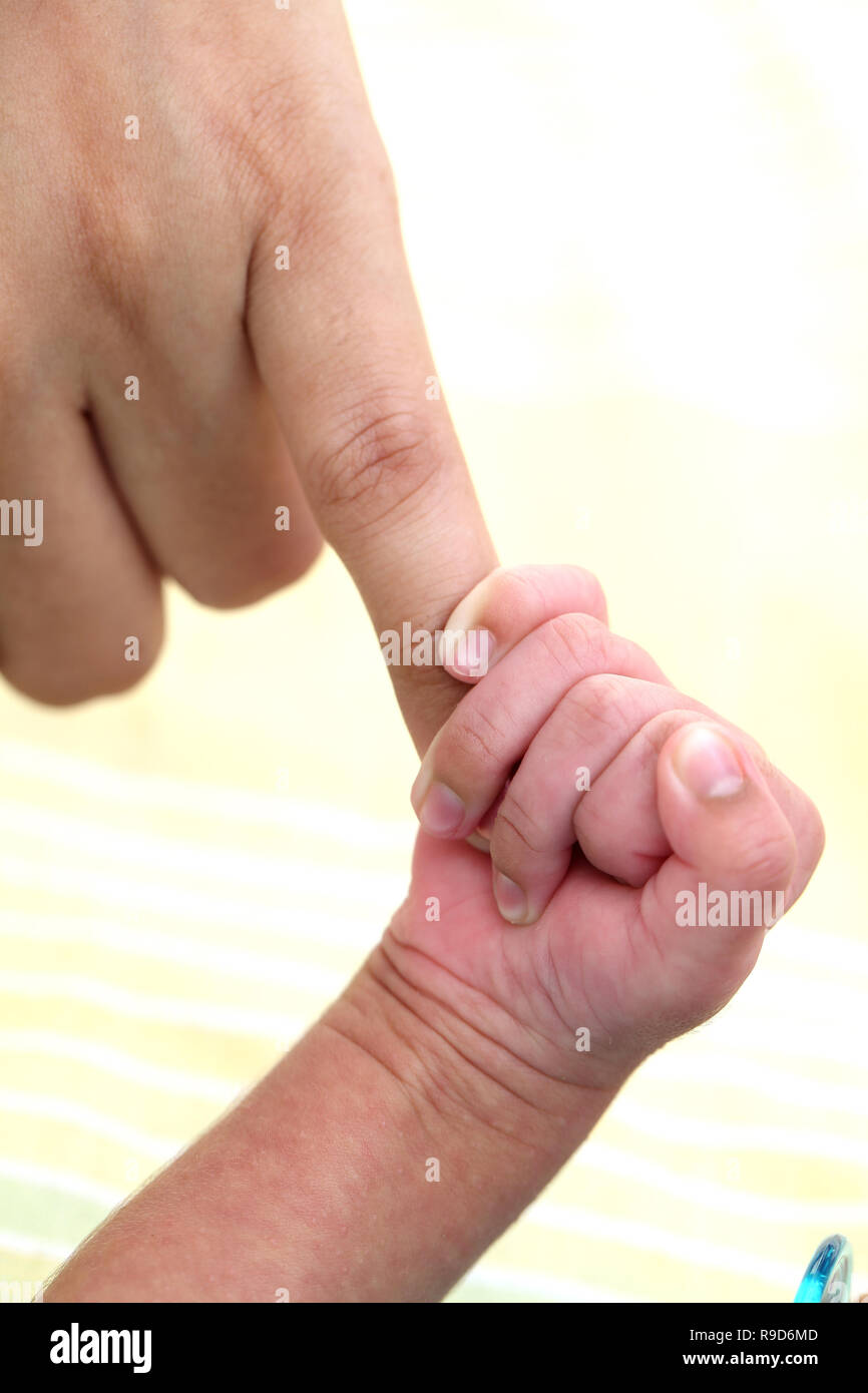 Newborn baby gripping mothers finger Stock Photo - Alamy