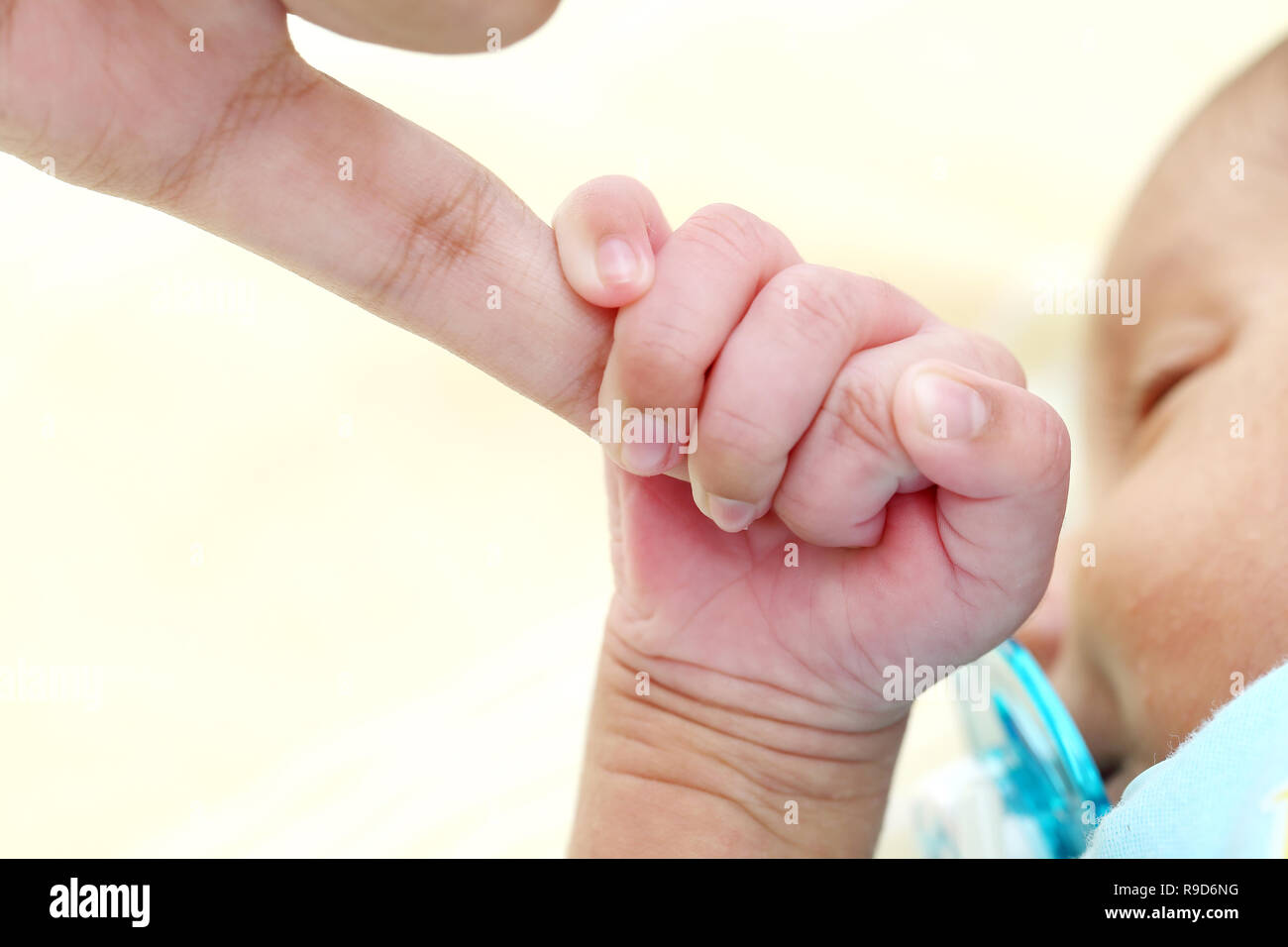 Newborn baby gripping mothers finger Stock Photo - Alamy