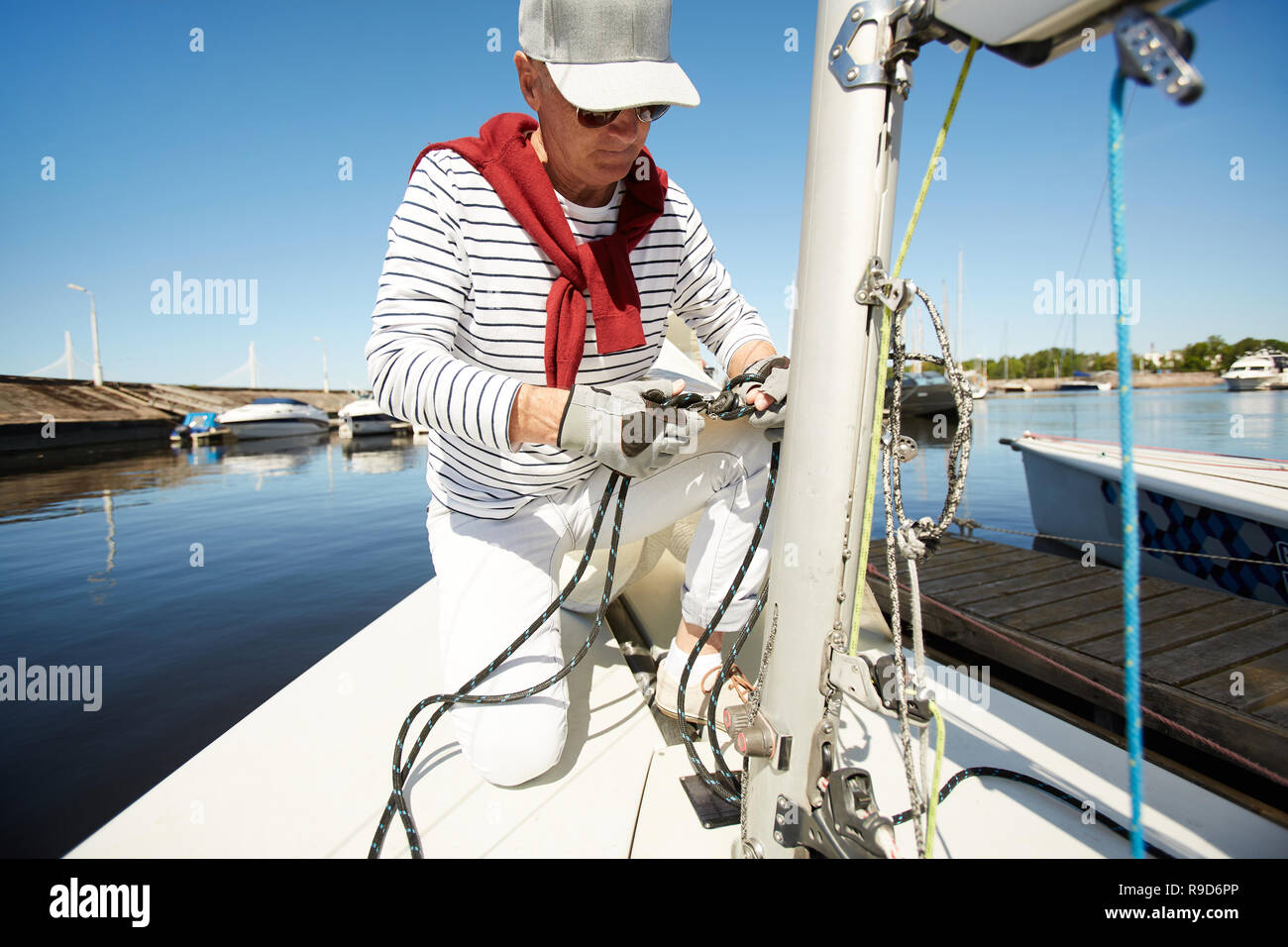 Sailor checking ropes Stock Photo - Alamy