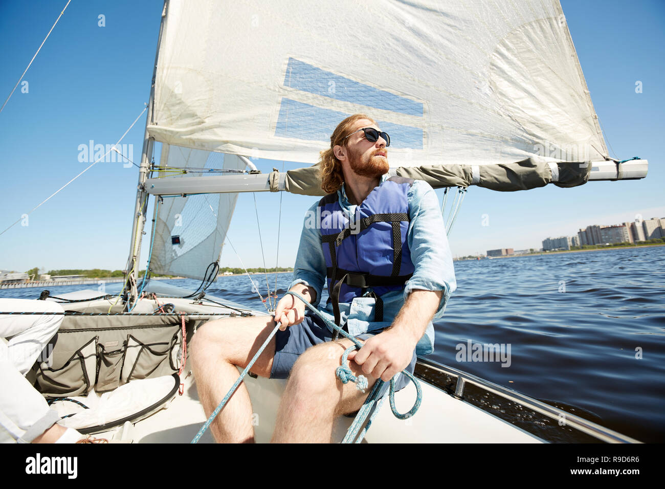 Pensive man with rope on sail boat Stock Photo - Alamy