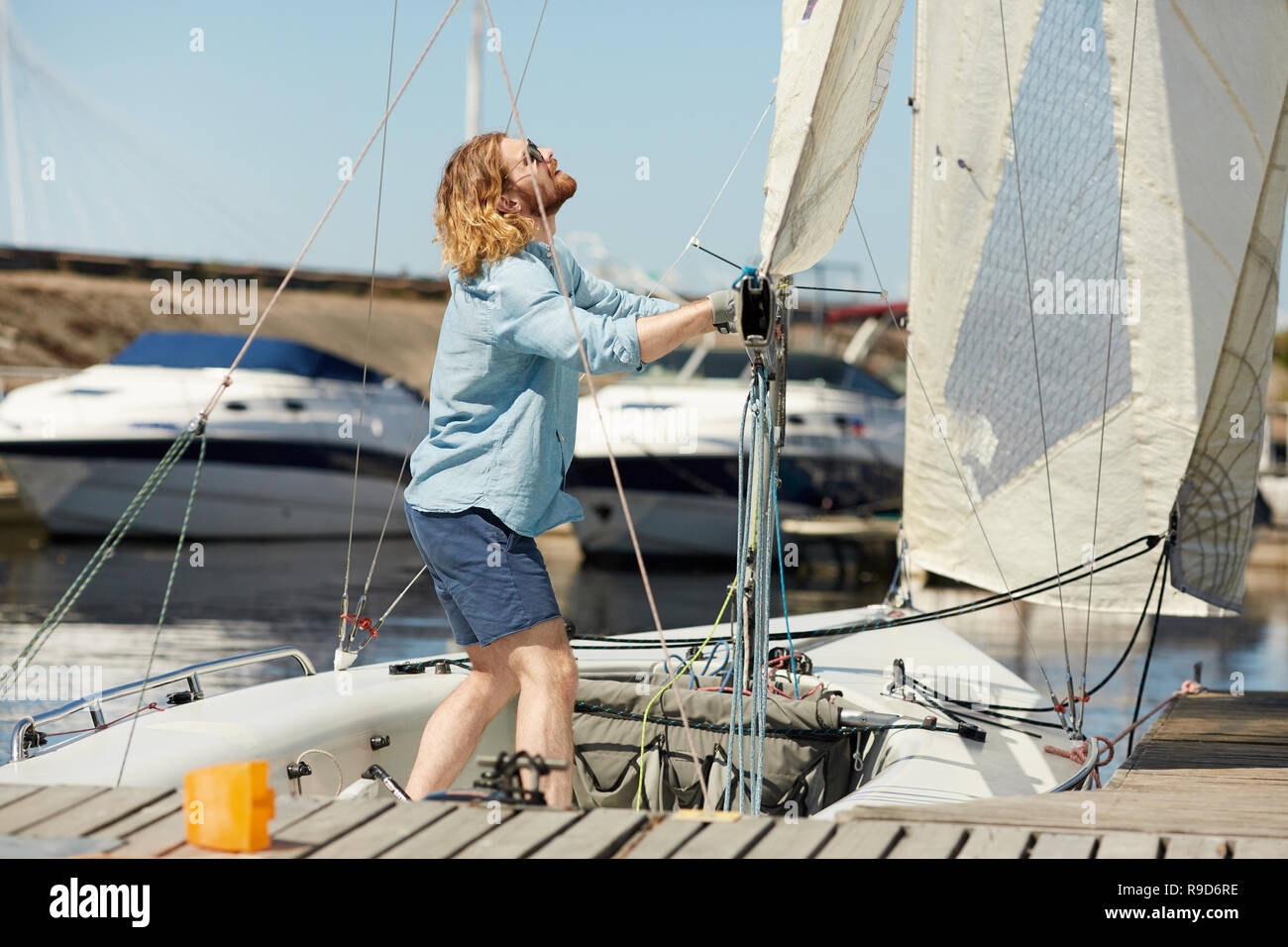Adjusting sail on boat Stock Photo - Alamy