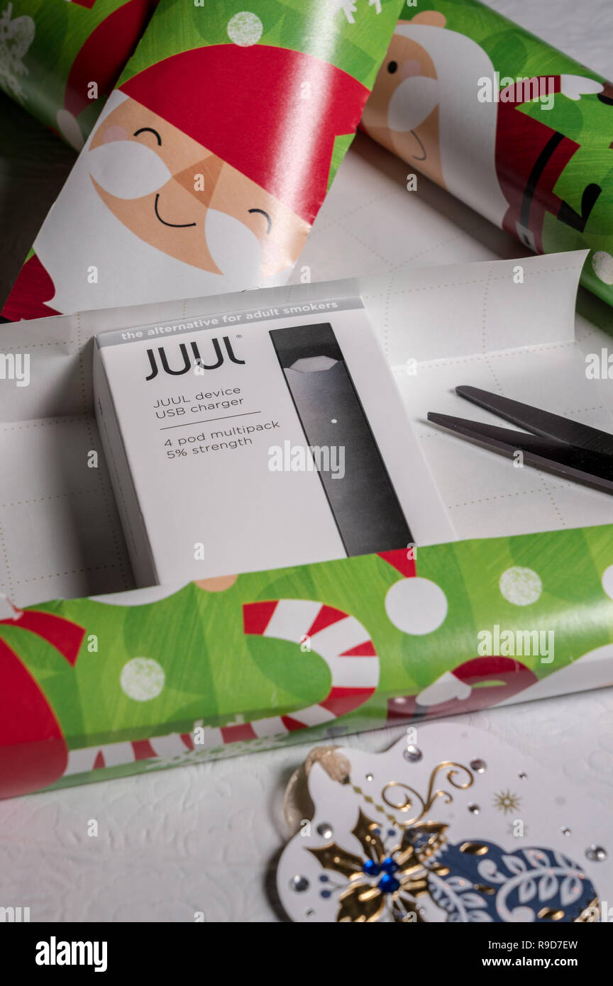 Box holding JUUL nicotine dispenser and pods on Christmas paper Stock ...