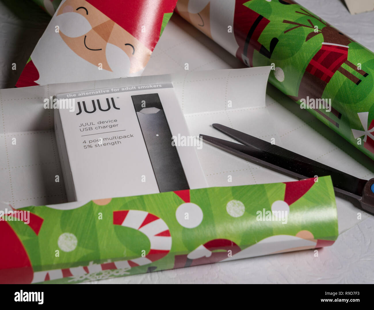 Box holding JUUL nicotine dispenser and pods on Christmas paper Stock ...