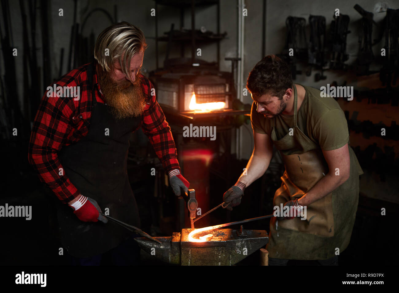 Blacksmiths forging iron Stock Photo - Alamy