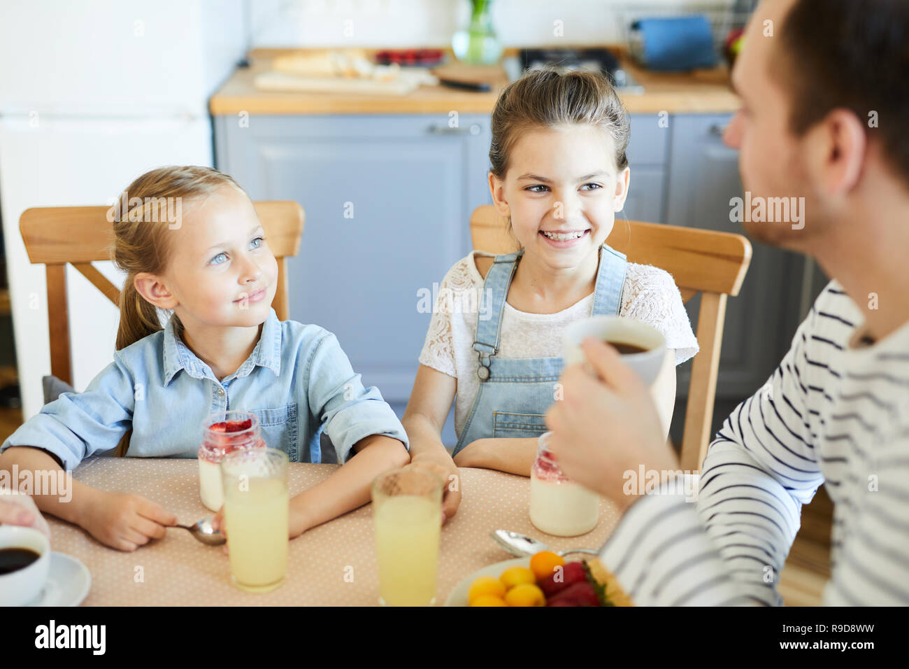 Girls talking to father Stock Photo - Alamy