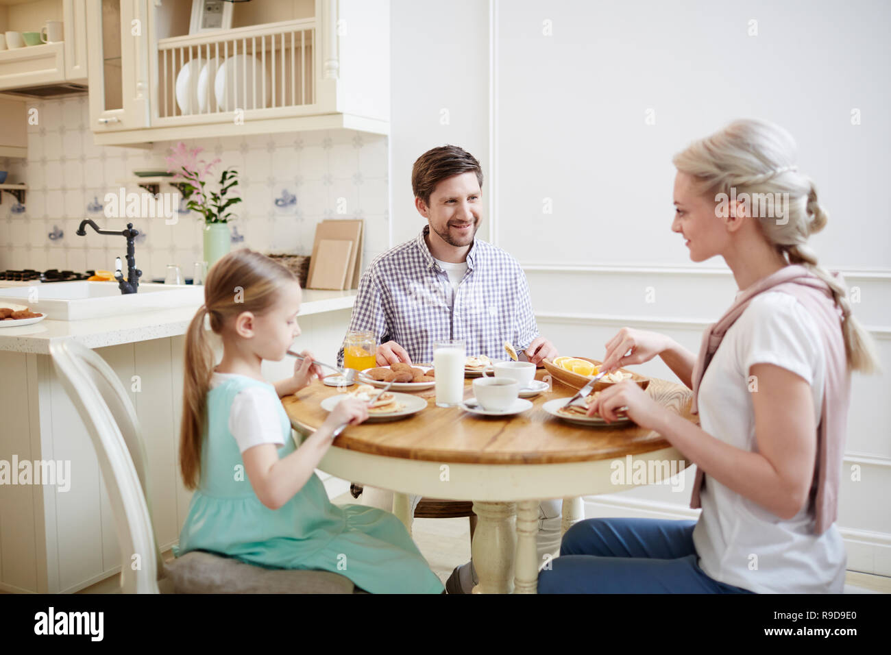 Smiling family members eating pancakes Stock Photo - Alamy