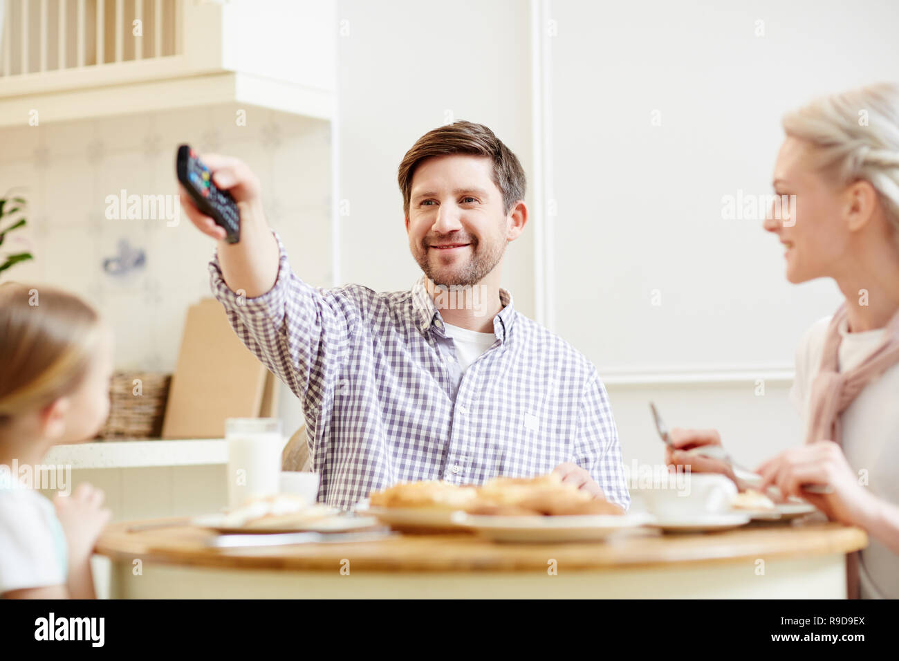 Watching tv at family dinner Stock Photo - Alamy