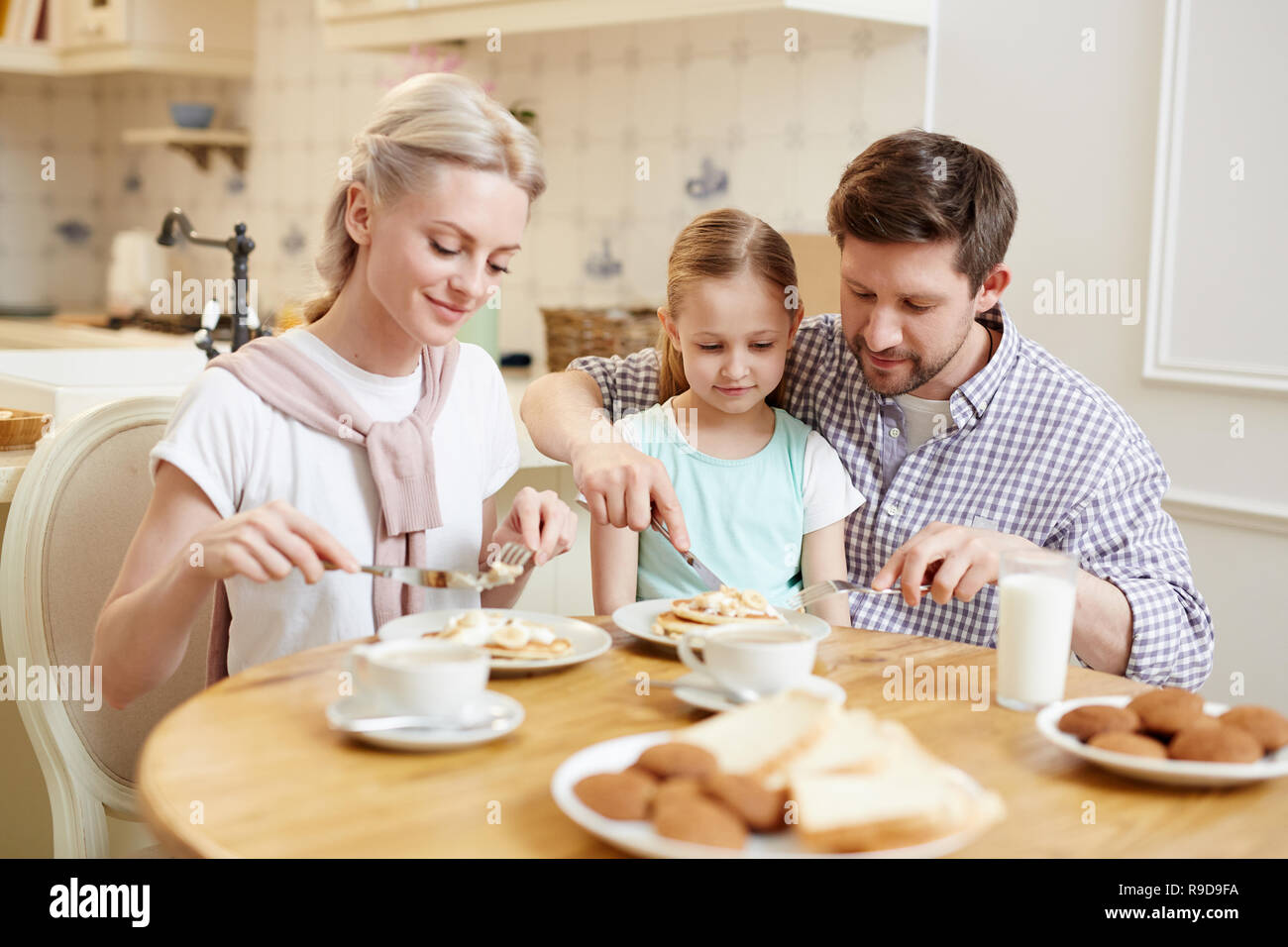 Happy friendly family eating breakfast in morning Stock Photo - Alamy
