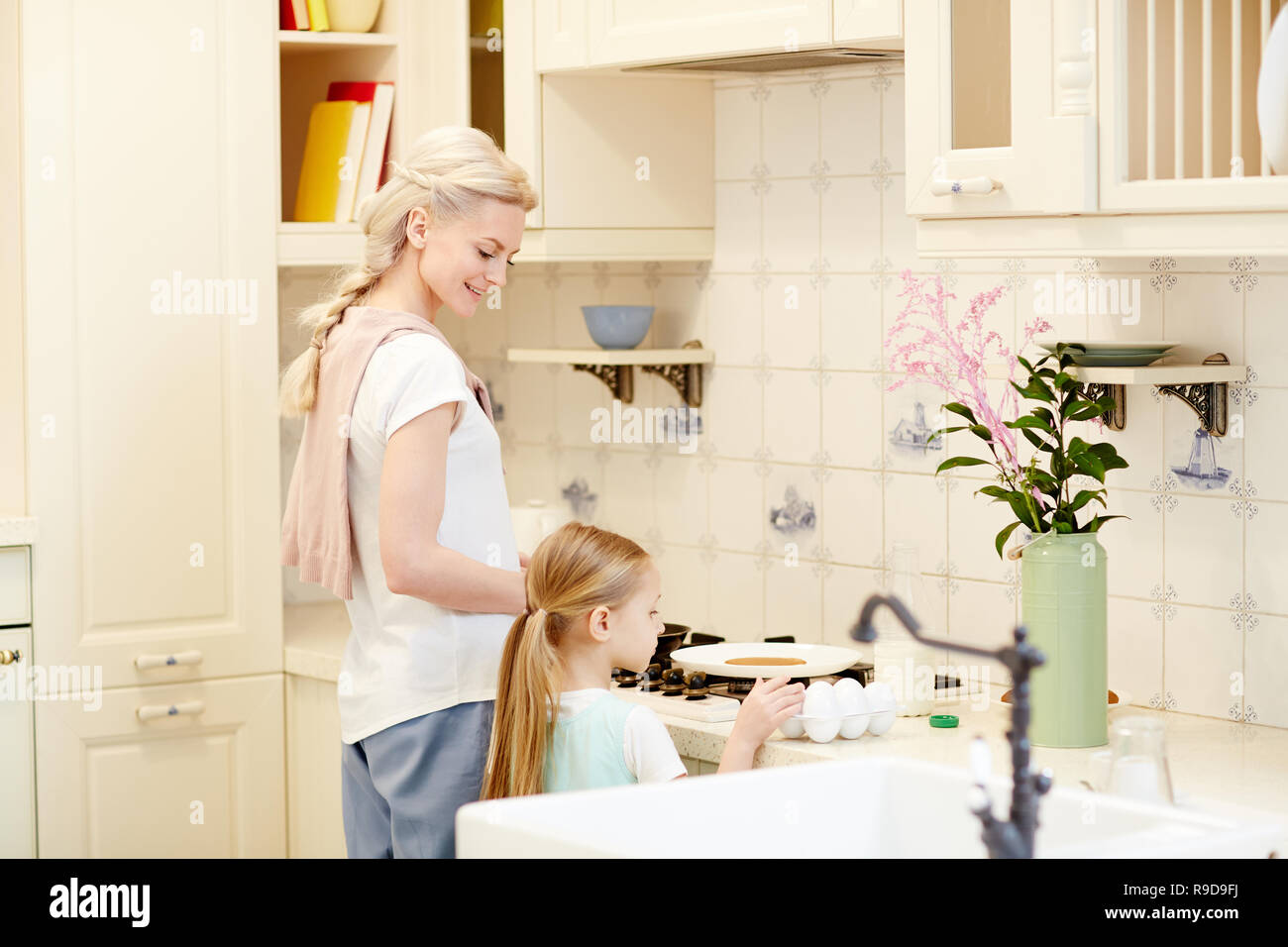 Mother teaching little daughter to cook pancakes Stock Photo - Alamy