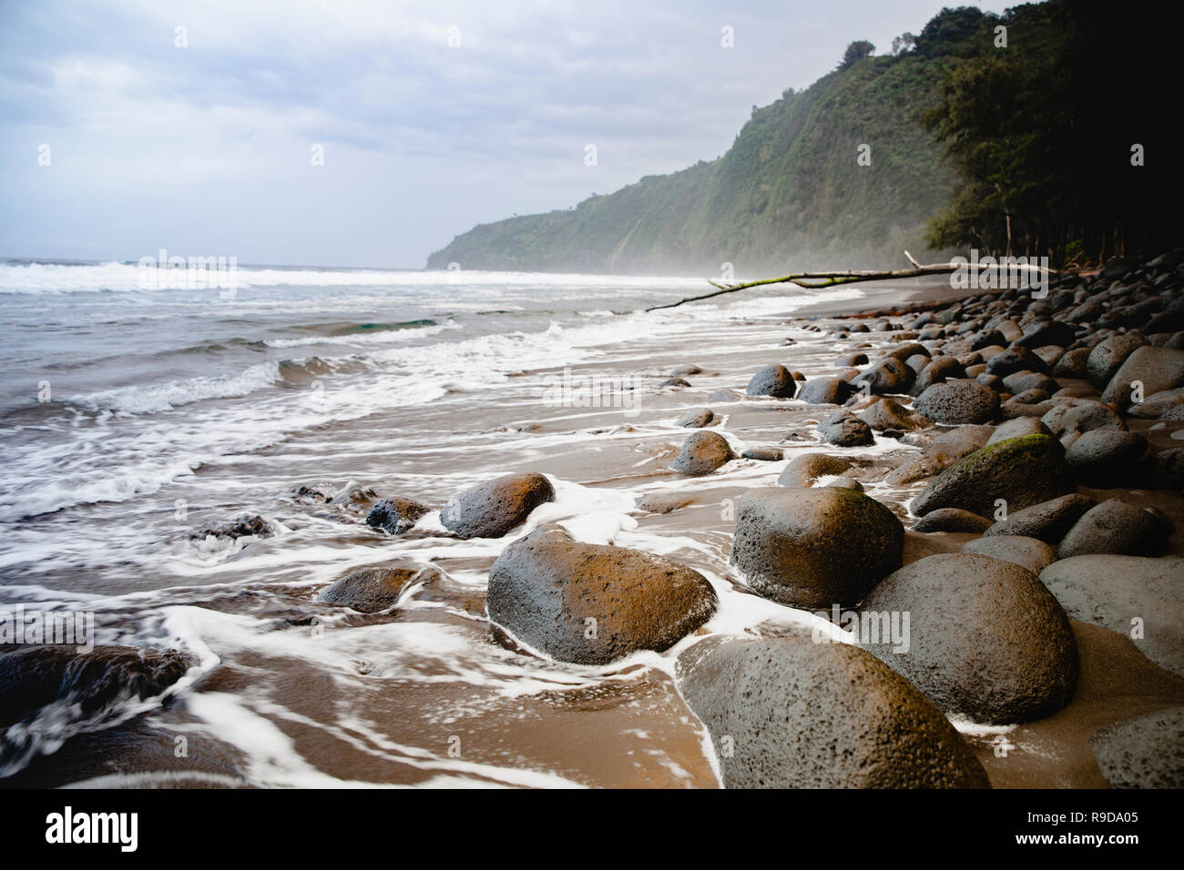 Waves crashing over rocks on the beach in Waipio Valley on the Big ...