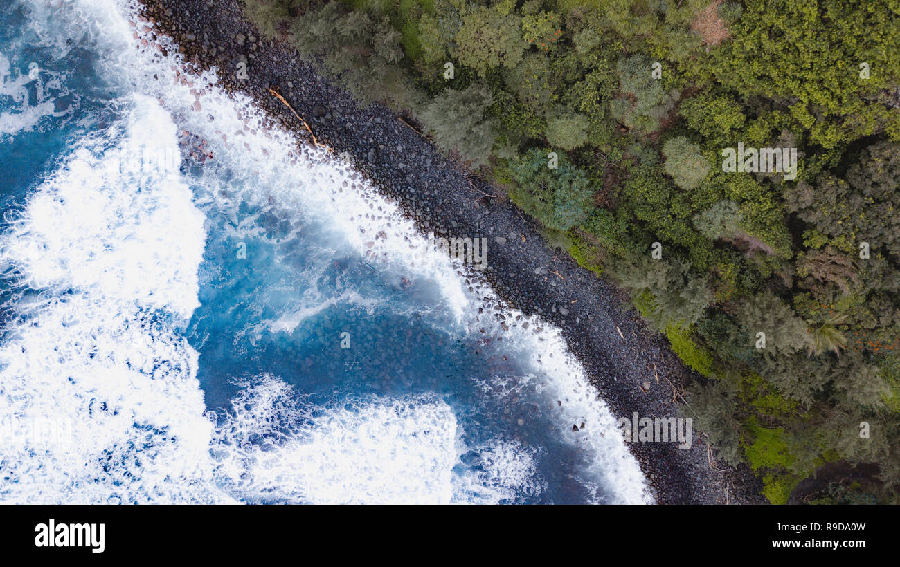 Overhead shots of waves crashing onto a black sand beach on the big ...