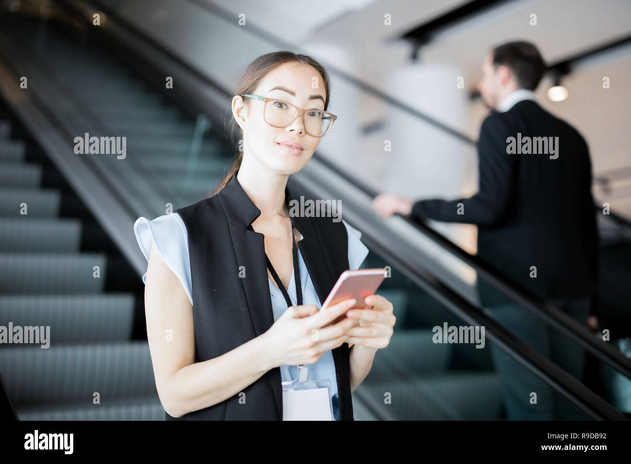 Professional man and woman on escalator hi-res stock photography and ...